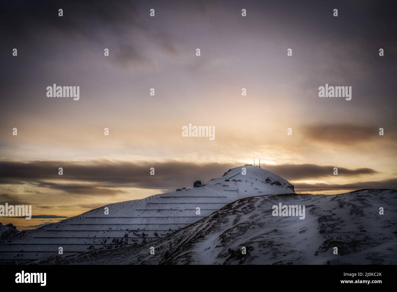 Stunning winter landscape of snow-capped rocky mountains under a cloudy ...