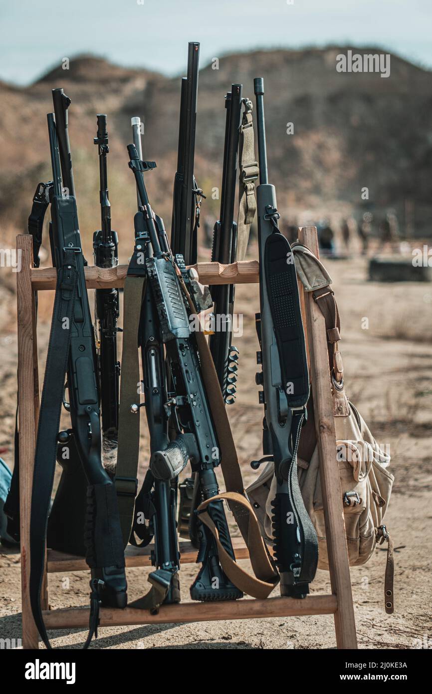 A variety of small arms on a wooden rack. Rifles, carbines and shotguns ...