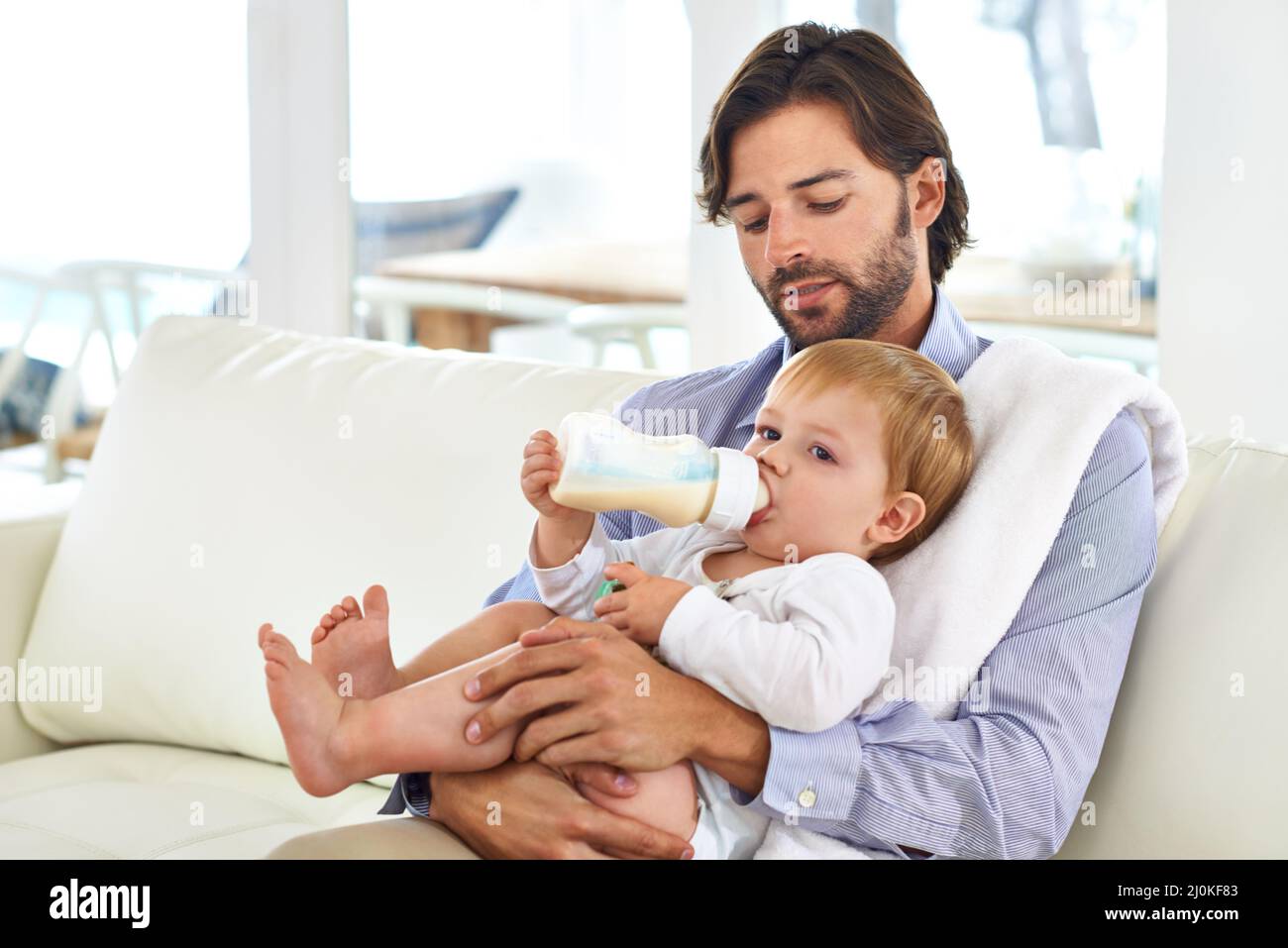 Feeding his baby. Cropped view of a father giving his young son a ...