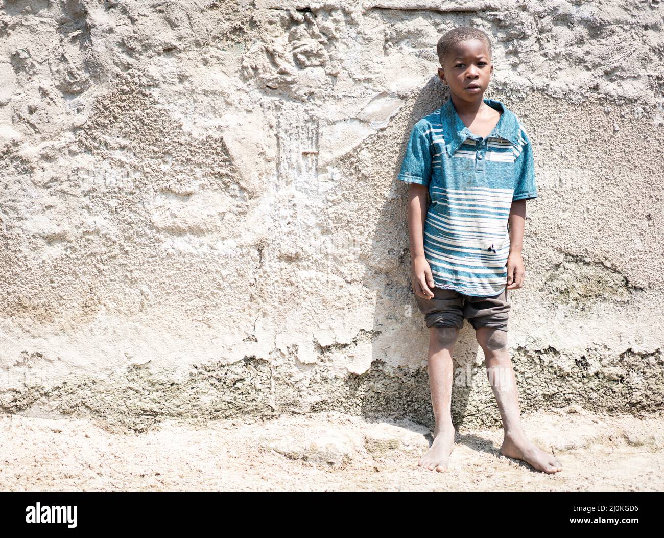African black boy portrait standing near his poor house Stock Photo - Alamy