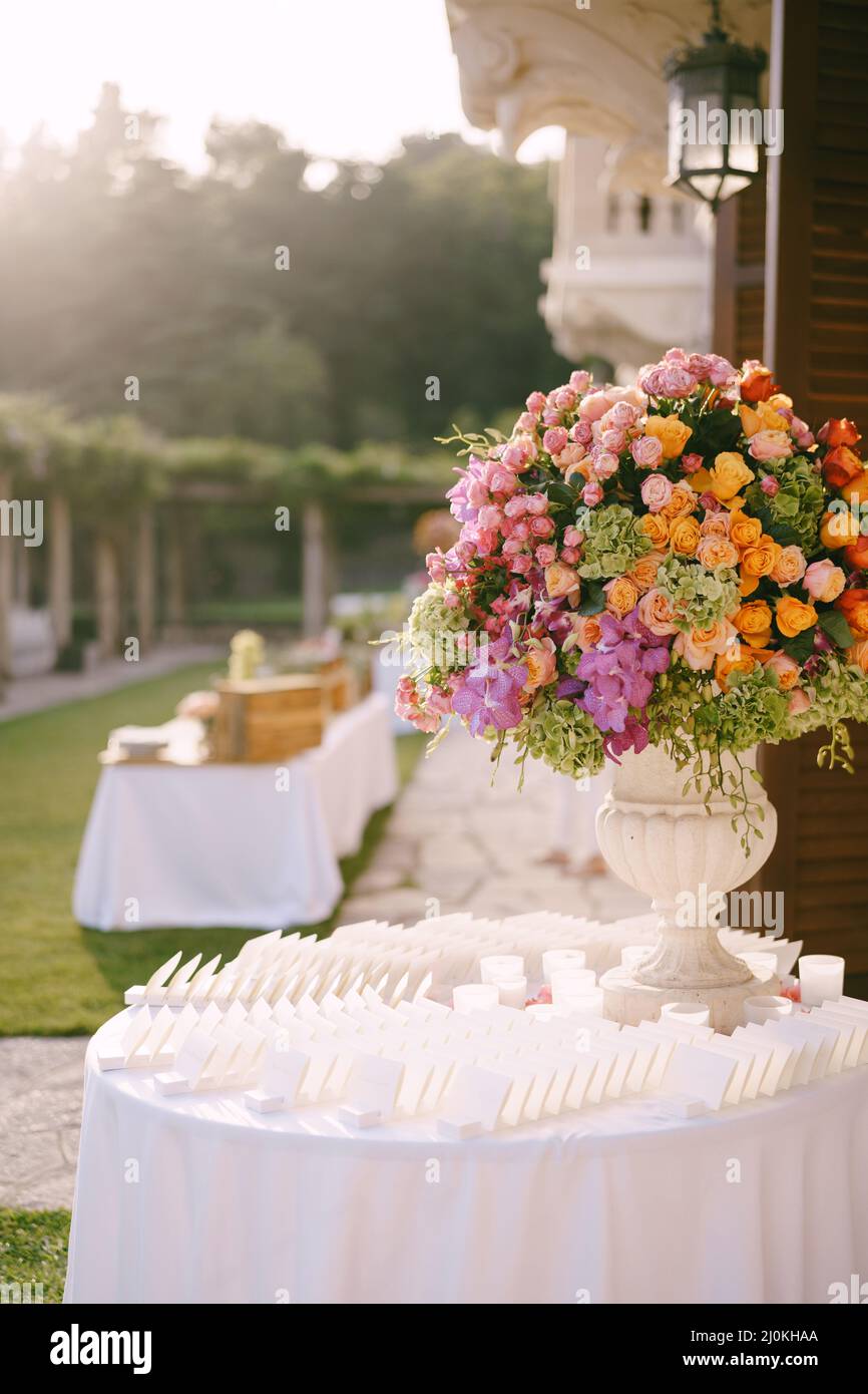 Wedding dinner table reception. A huge bouquet in an old marble vase of ...