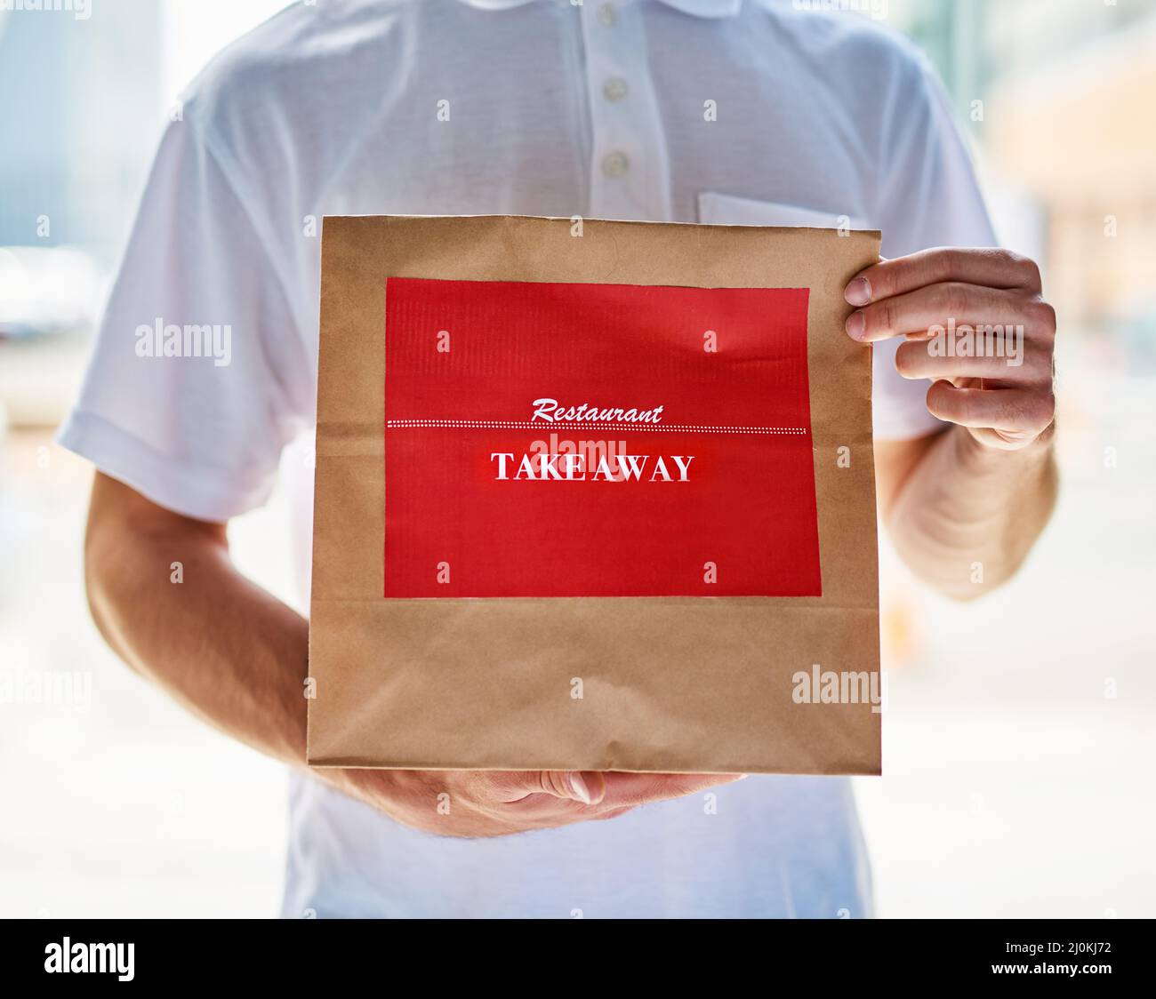 Lunch is ready. Cropped shot of a delivery man holding a restaurant ...