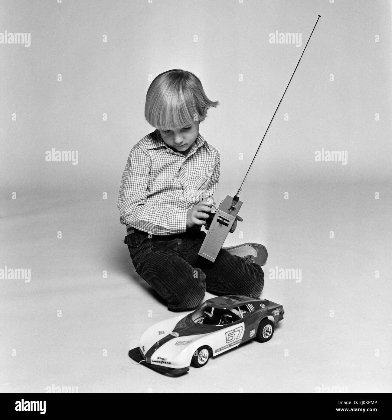 A young boy playing with a remote control car. December 1980 Stock ...