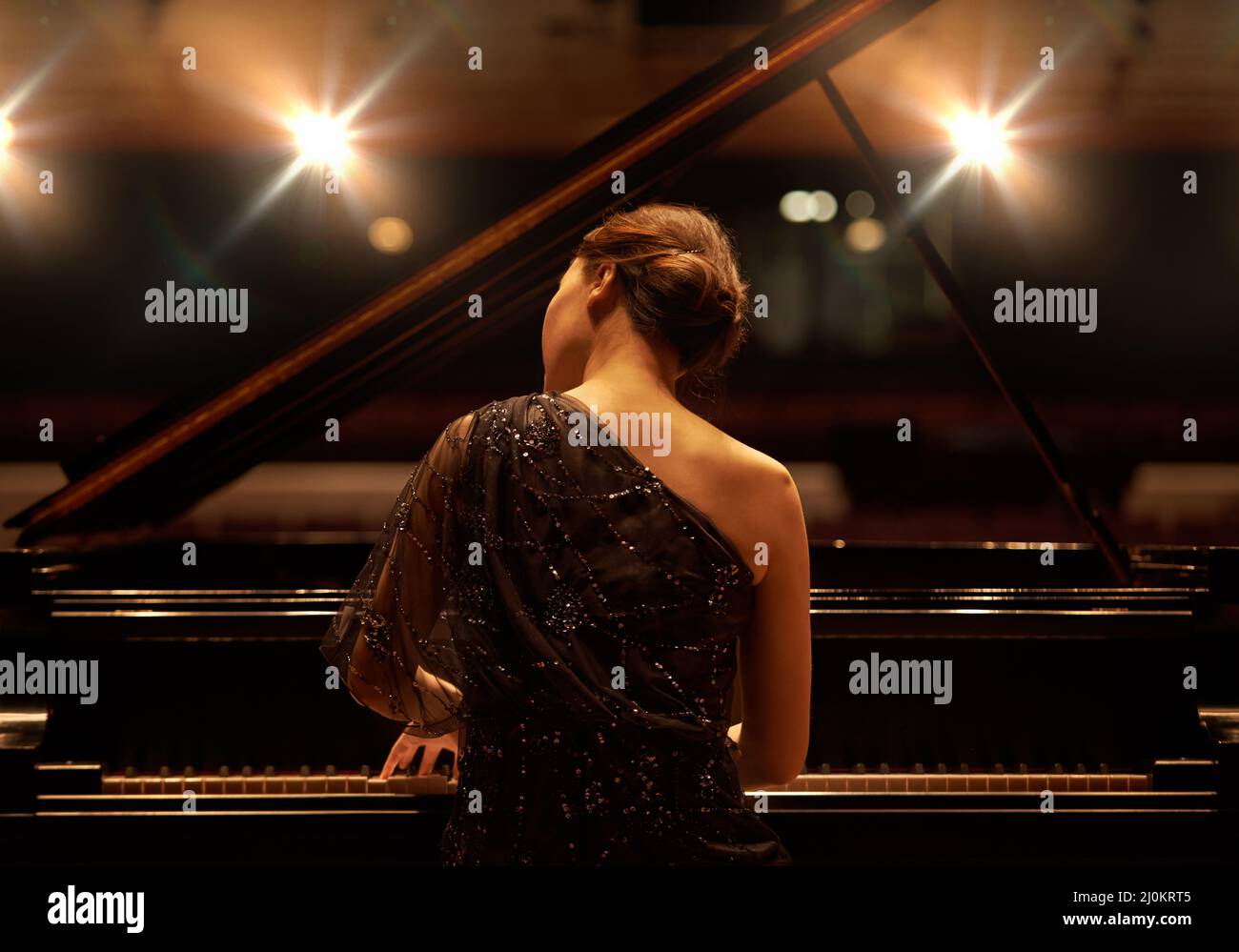 Performing for the audience. Shot of a young woman playing the piano ...