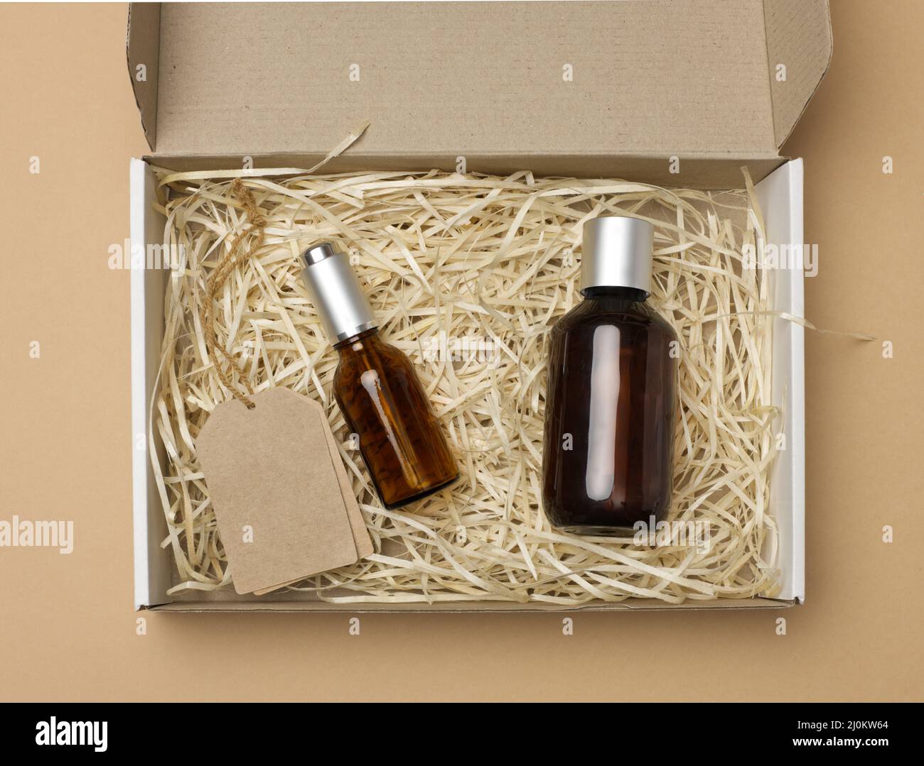 Brown glass bottles for cosmetics and paper tags on a rope lie in a ...