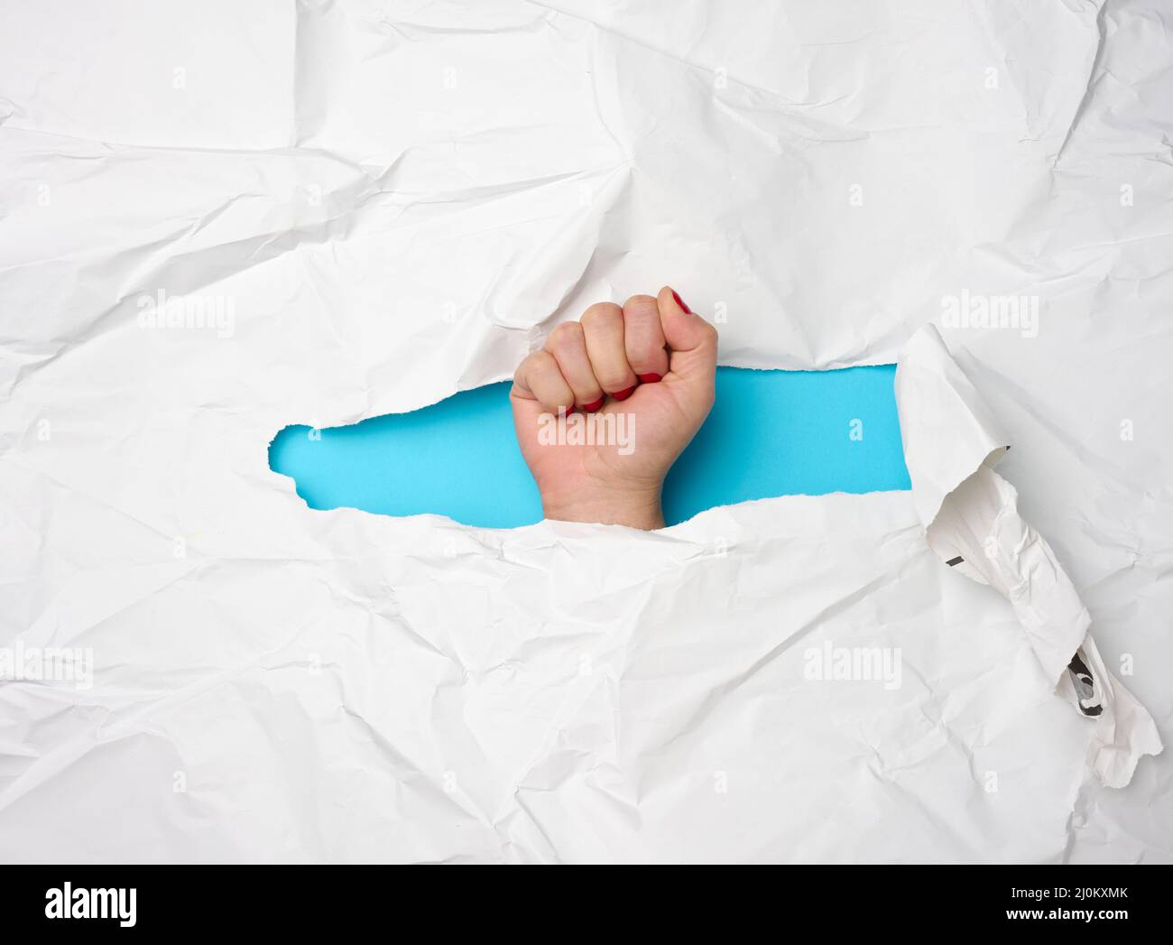 Female fist sticking out of torn hole on white paper, freedom Stock ...