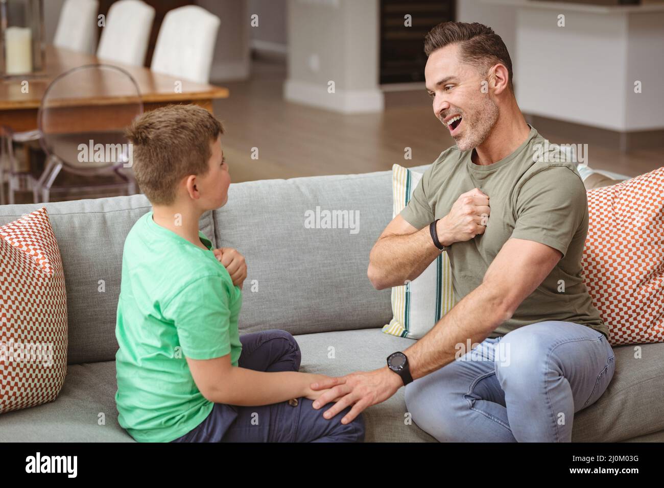 Caucasian father and son communicating using sign language while ...