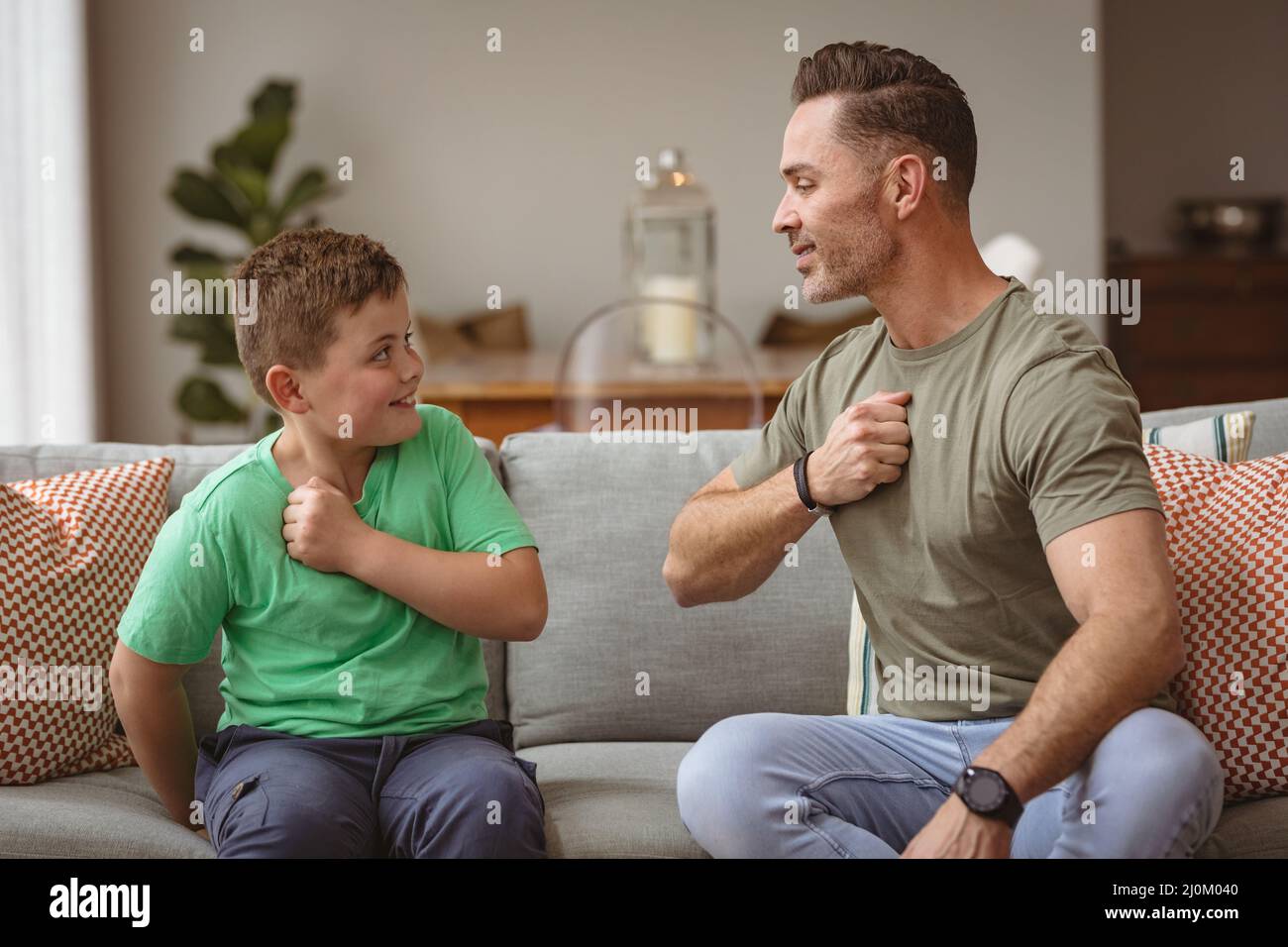 Caucasian father and son communicating using sign language while ...