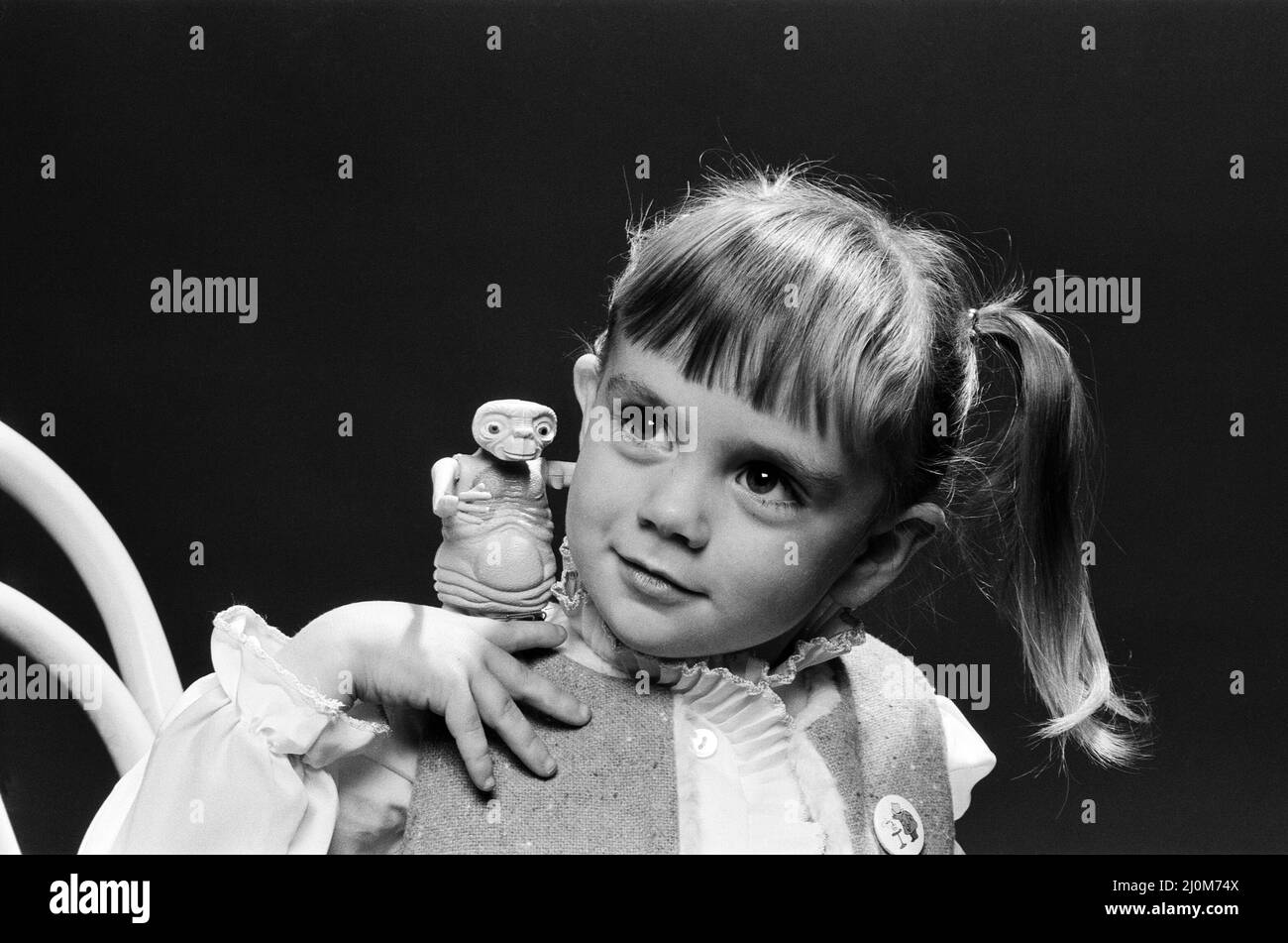 A young girl holding an E.T. from the film E.T. the Extra-Terrestrial ...