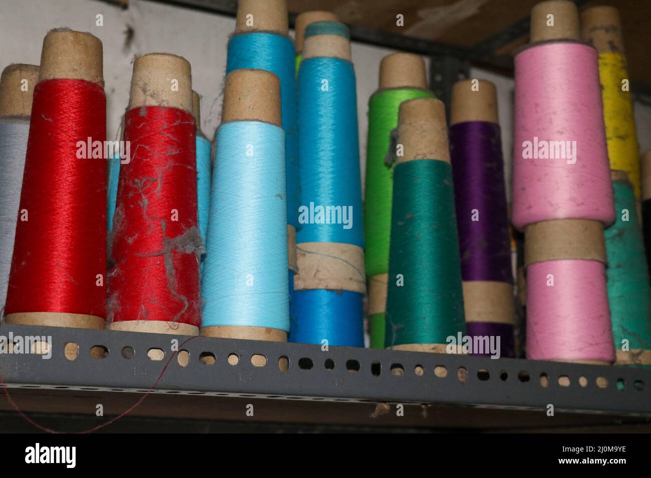 Set of colored threads for sewing on coils. Pile of big colorful spools ...