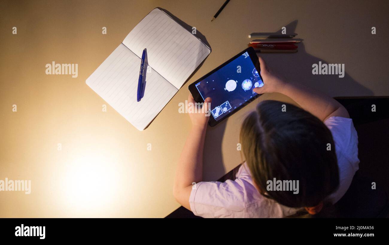Girl playing tablet game evening Stock Photo - Alamy