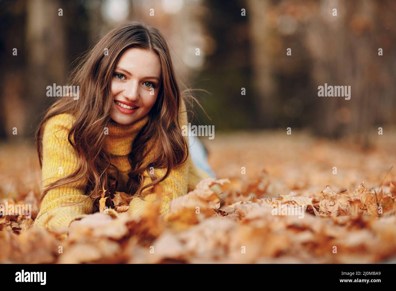 Woman lying in fall leaves hi-res stock photography and images - Alamy