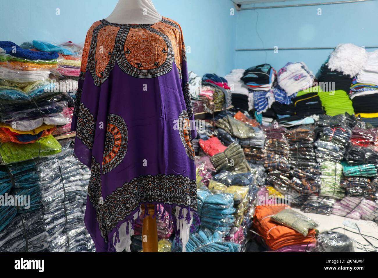 Poncho on a mannequin. Packages of colorful fabrics and variations of ...