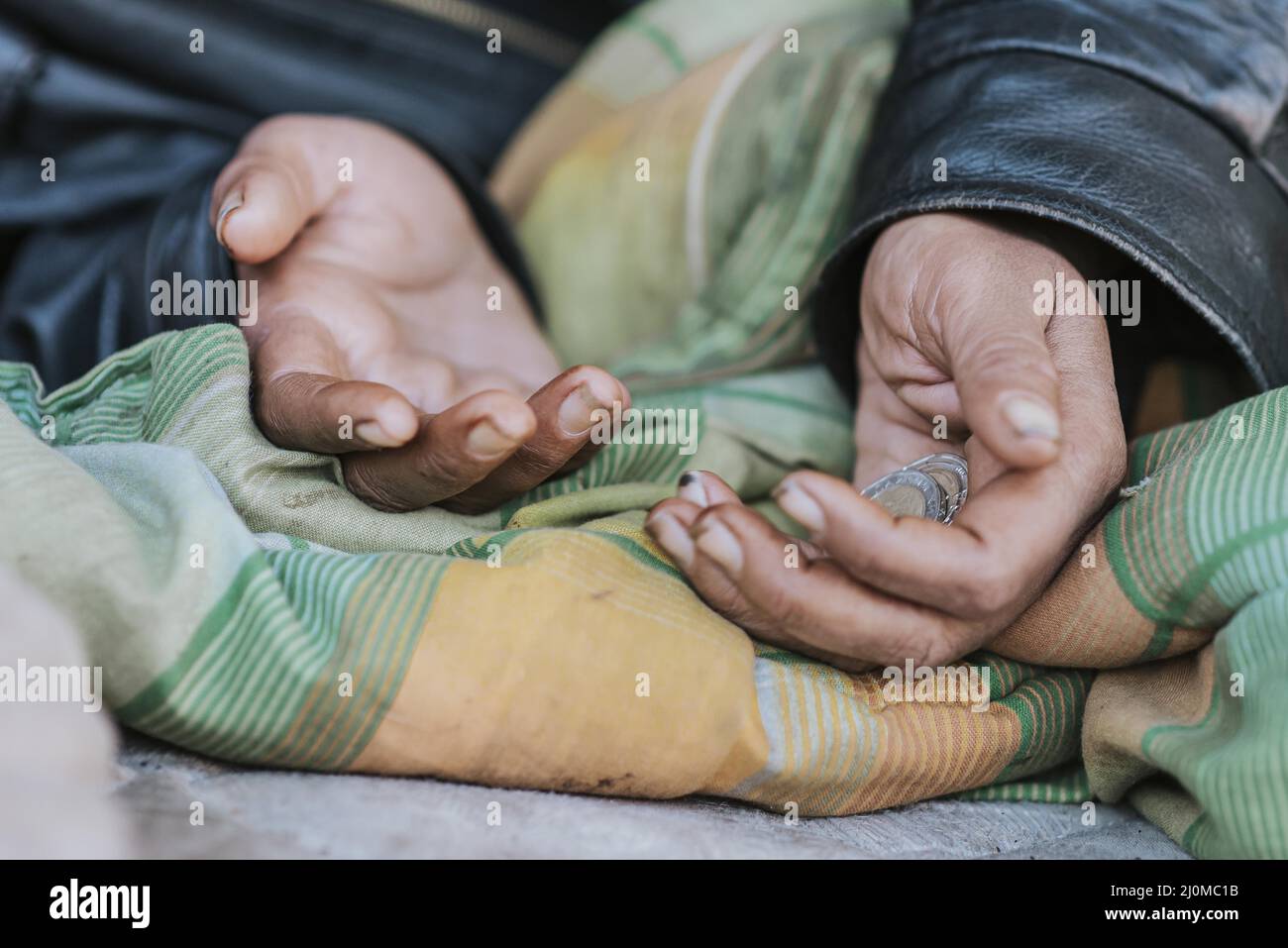 Homeless woman holding hands out for help Stock Photo - Alamy
