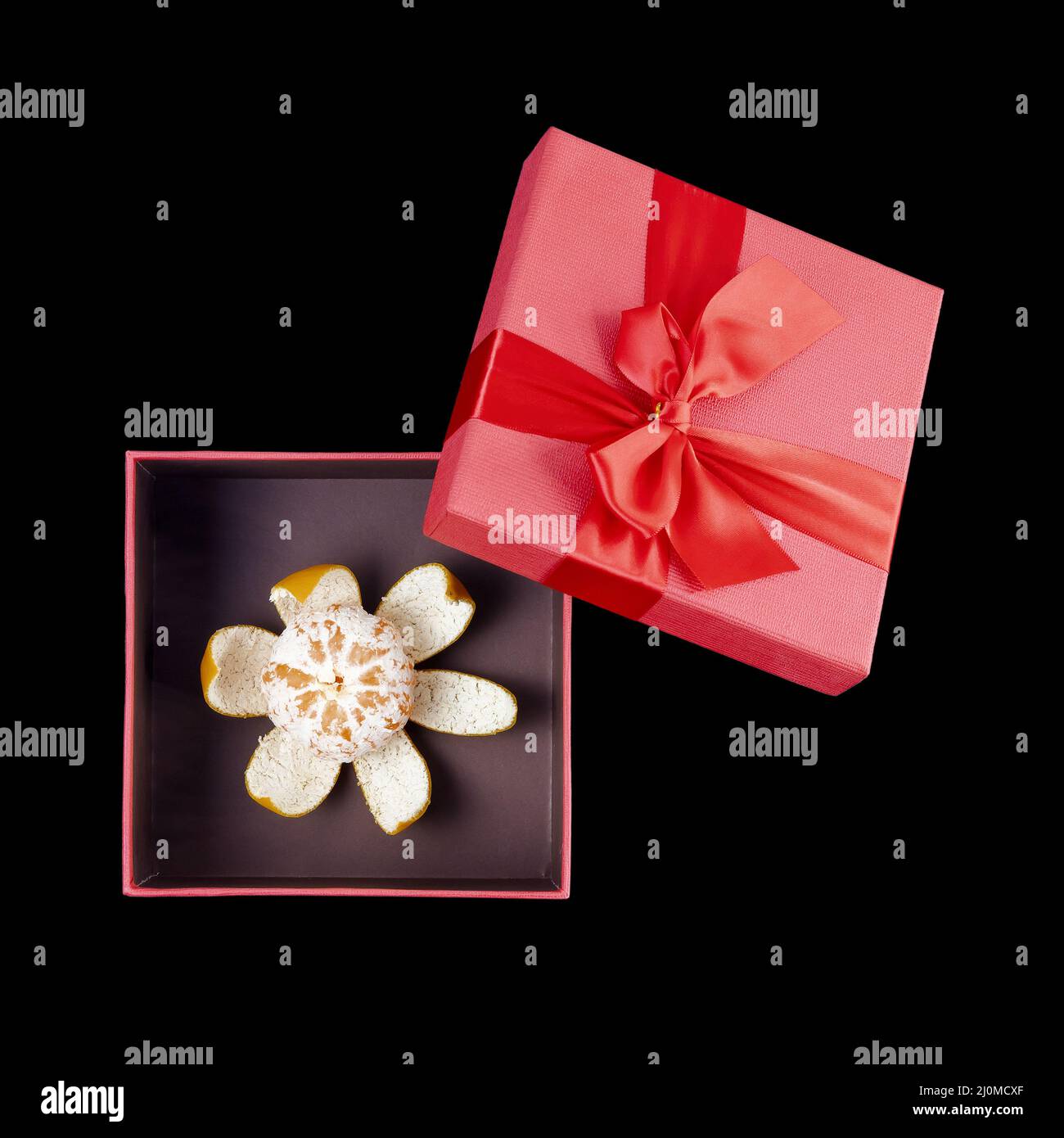 Open gift box with cleaned tangerine in it. Black isolated background ...