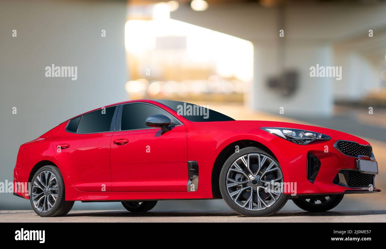 A red car on a background of city environment. Stylish, modern, bright ...