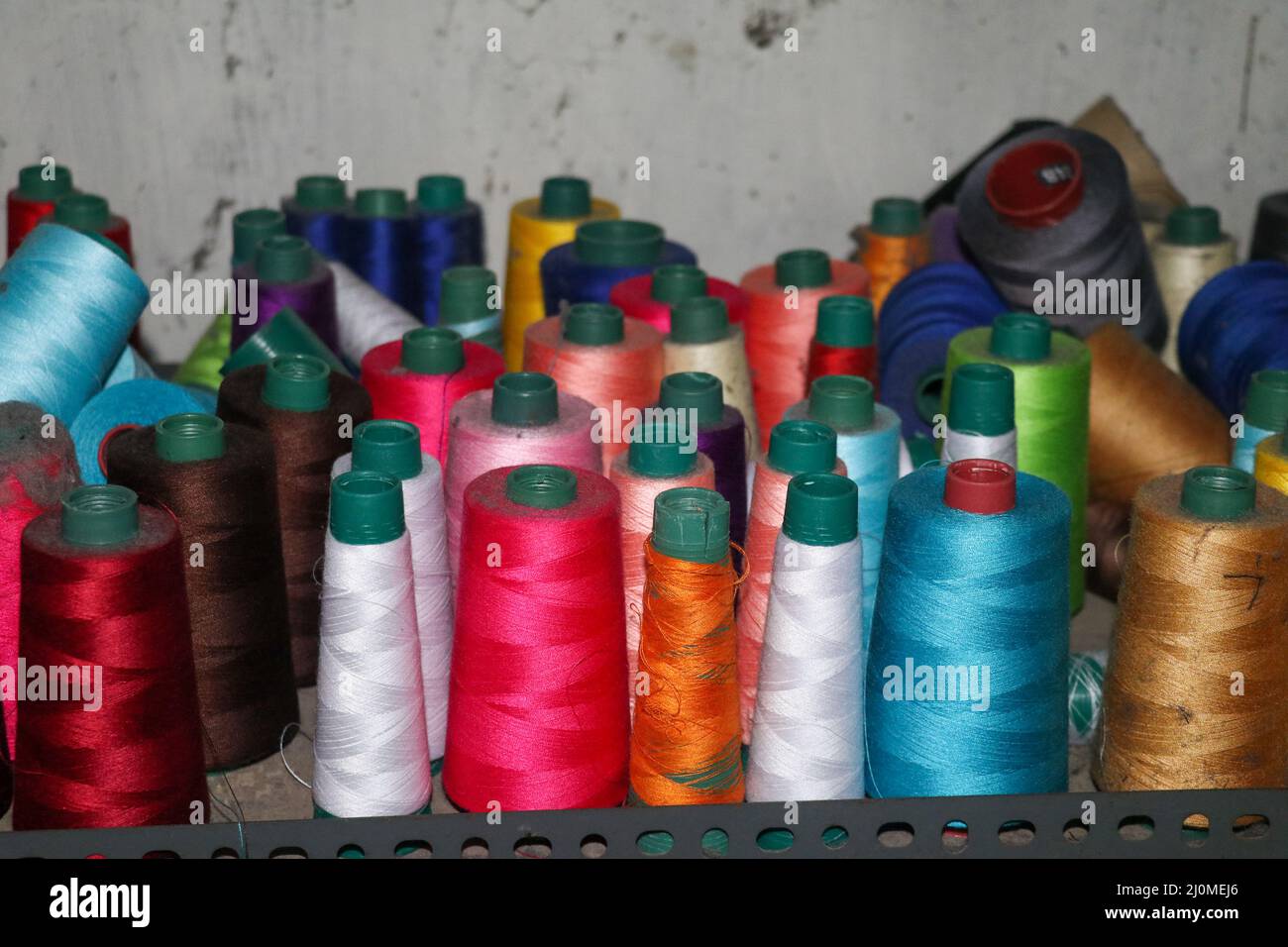 Set of colored threads for sewing on coils. Pile of big colorful spools ...