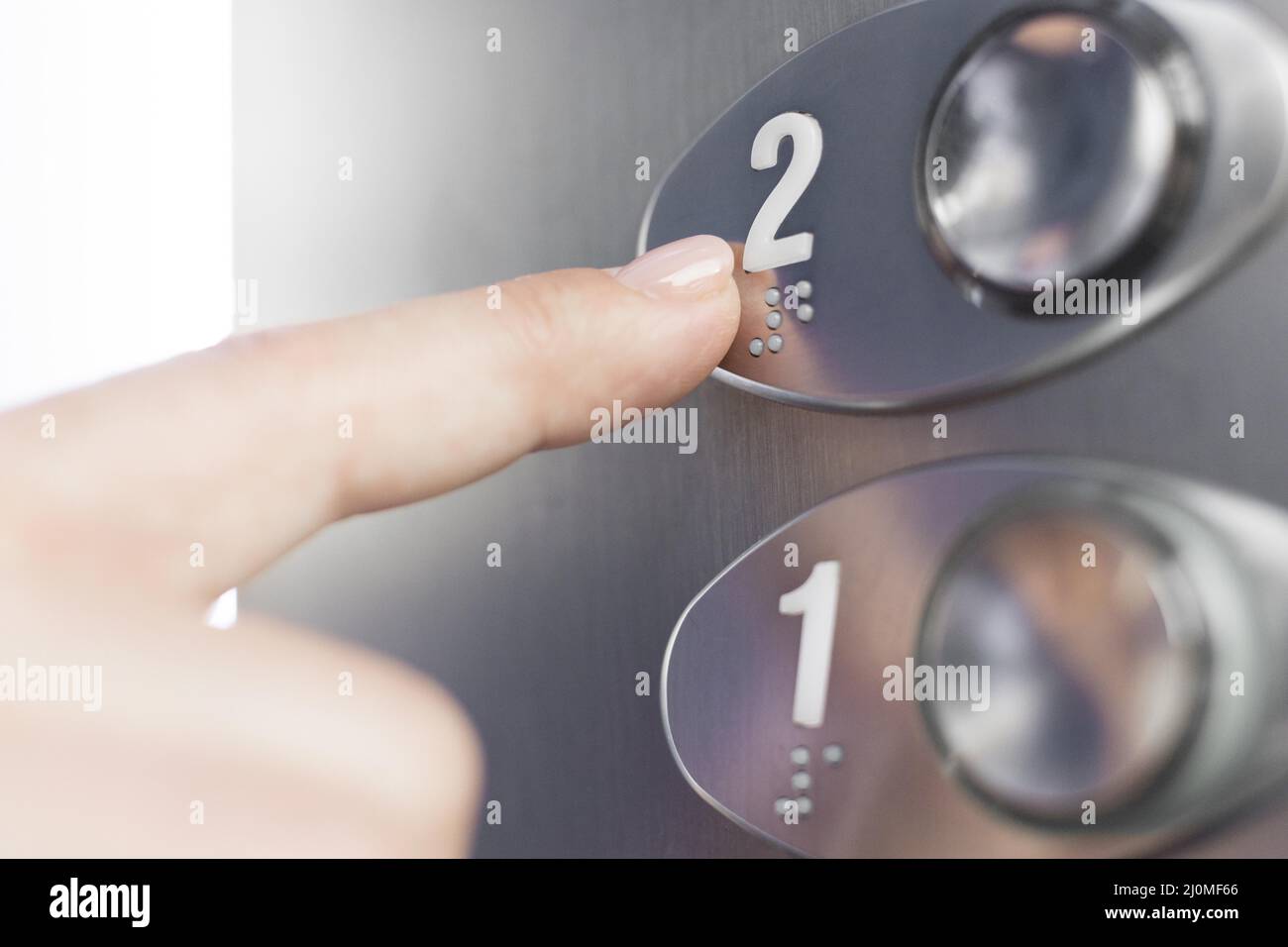 Hand touching elevator braille figure 1 Stock Photo - Alamy