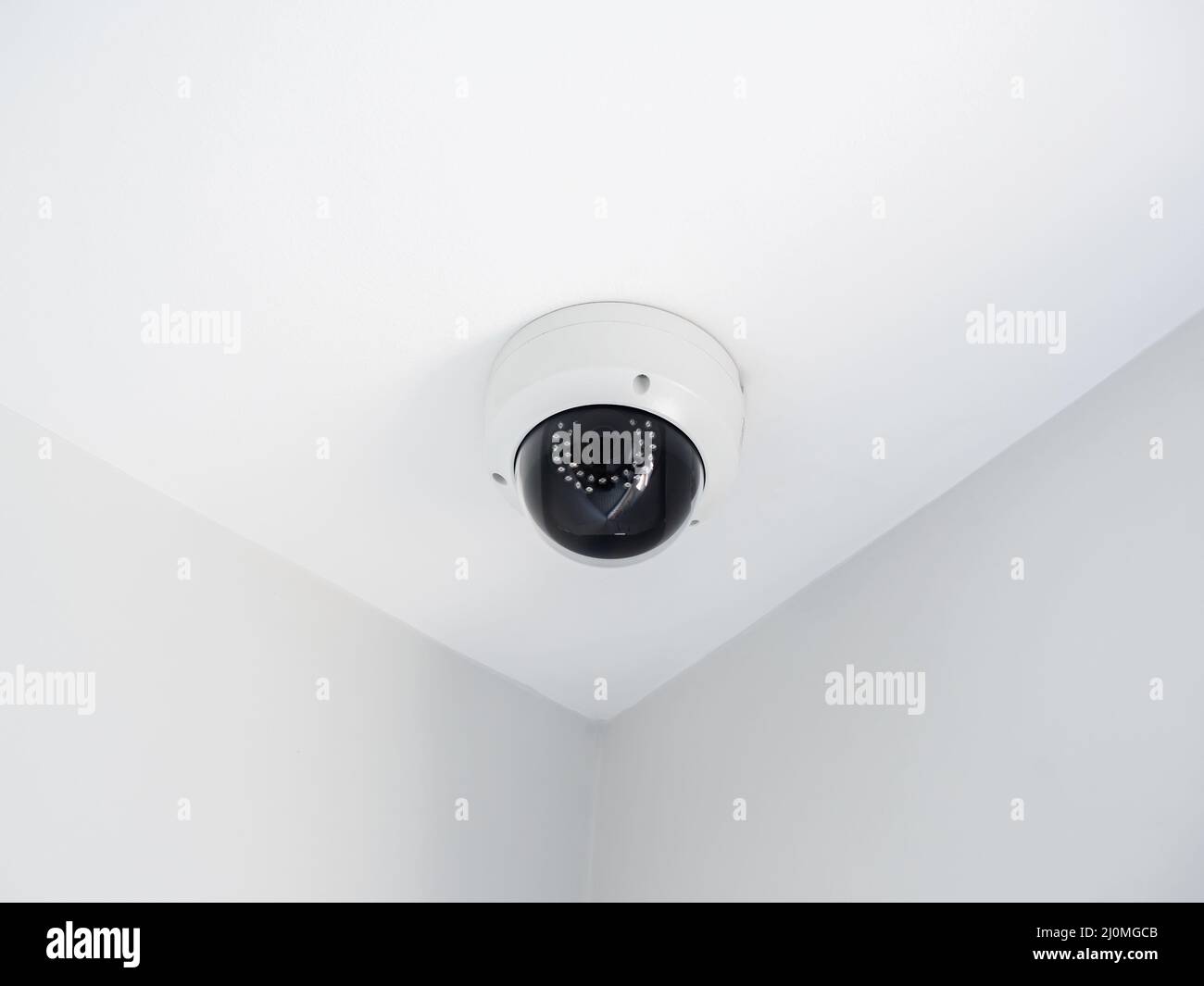 Digital security eye. A white round indoor CCTV surveillance camera ...
