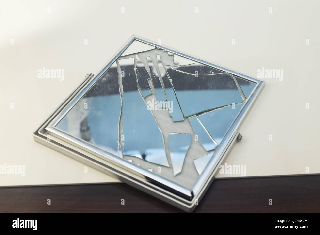 Broken mirror with shattered glass with silver frame on white ...
