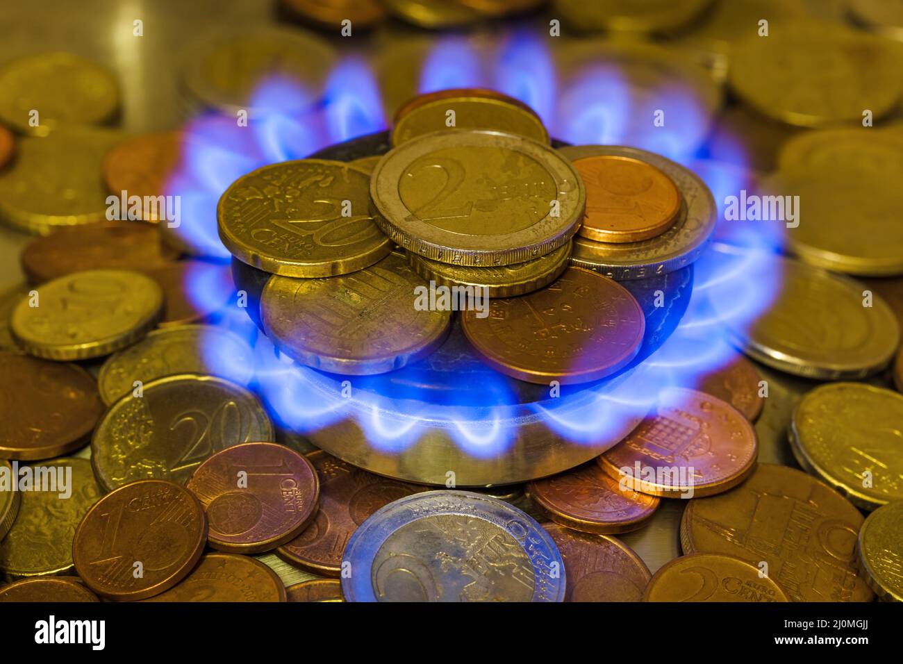Coins of on the gas burner of the kitchen stove Stock Photo - Alamy
