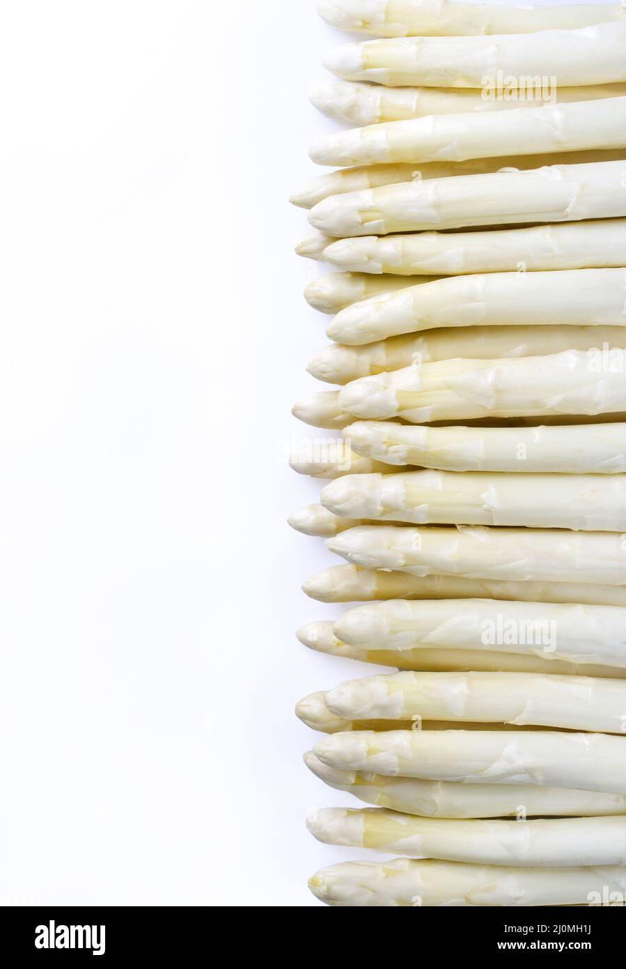 Raw white Asparagus beaded in a row as close-up with copy space left â ...