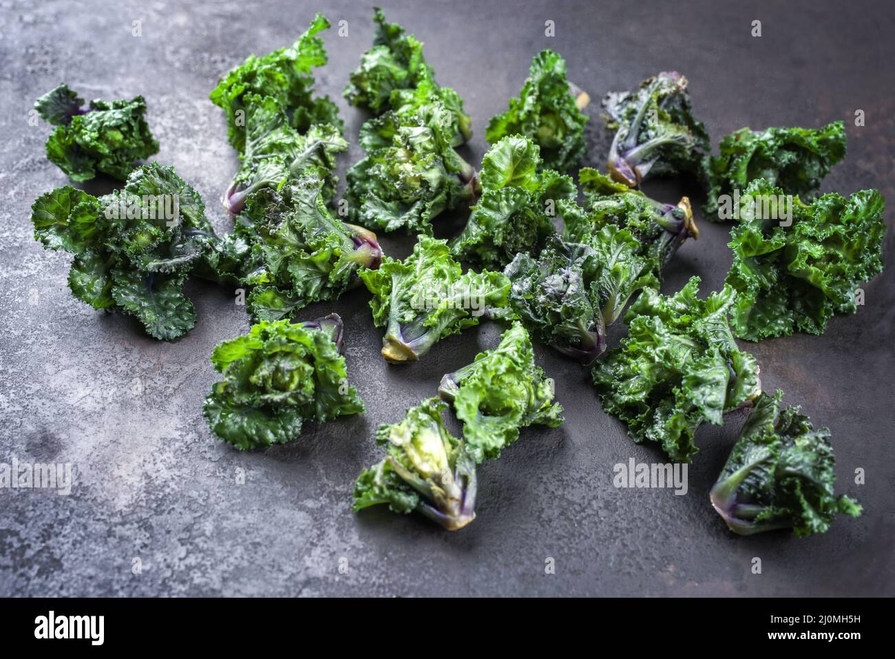 Fresh superfood kalette as top view on a black board with copy space ...