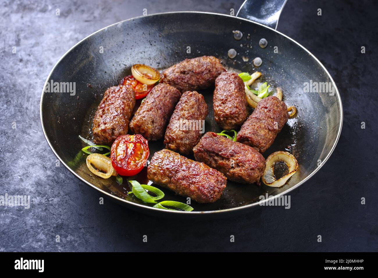 Traditional Croatian cevapi spicy meat ball rolls with tomatoes and ...