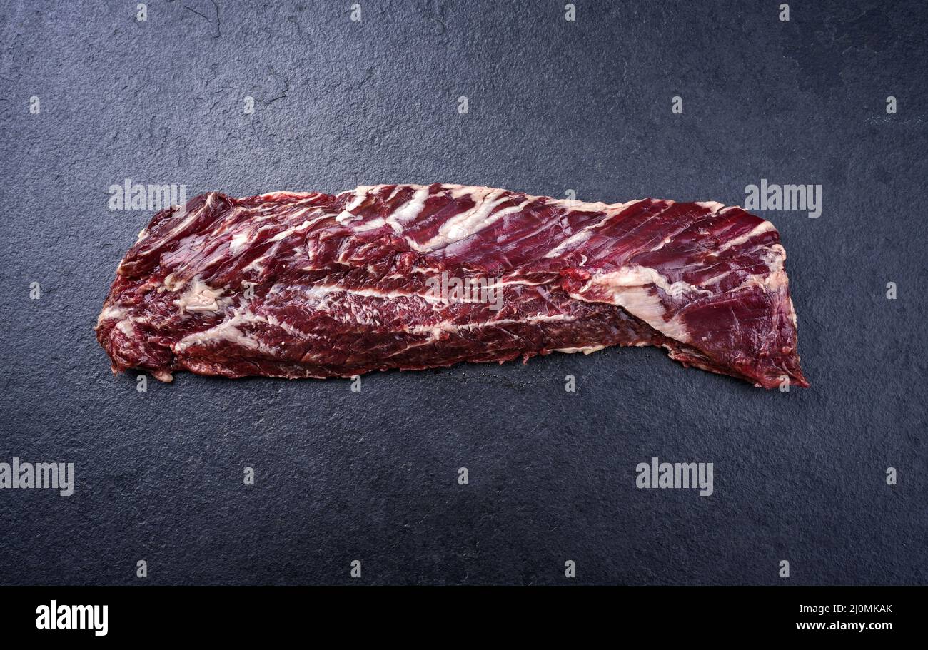 Raw wagyu onglet beef steak offered as top view on a black board with ...