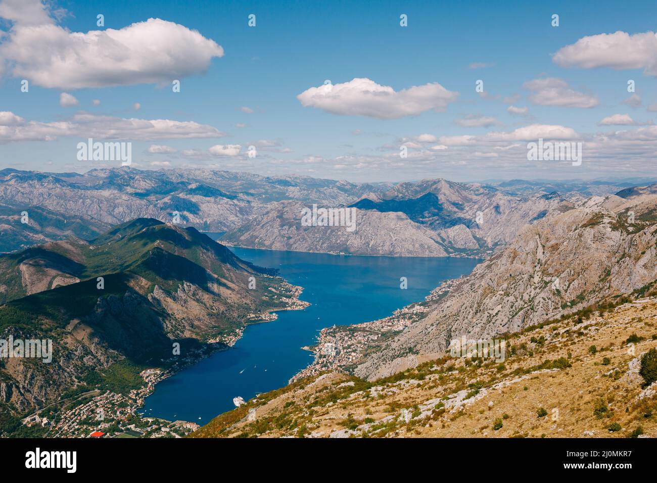 Blue sky with white clouds over the azure water of the Bay of Kotor ...