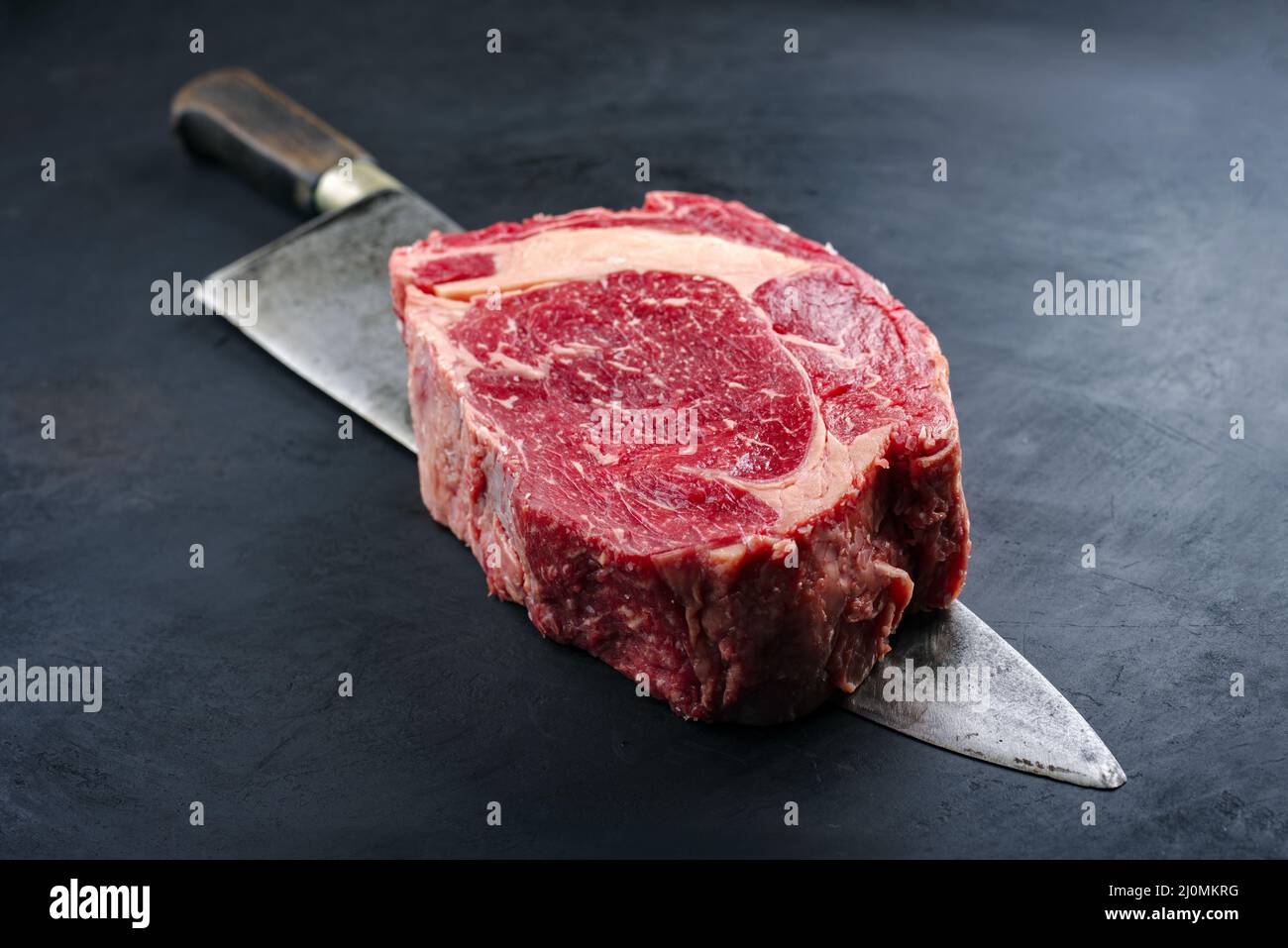 Raw dry aged wagyu rib-eye beef steaks offered as close-up on a large ...
