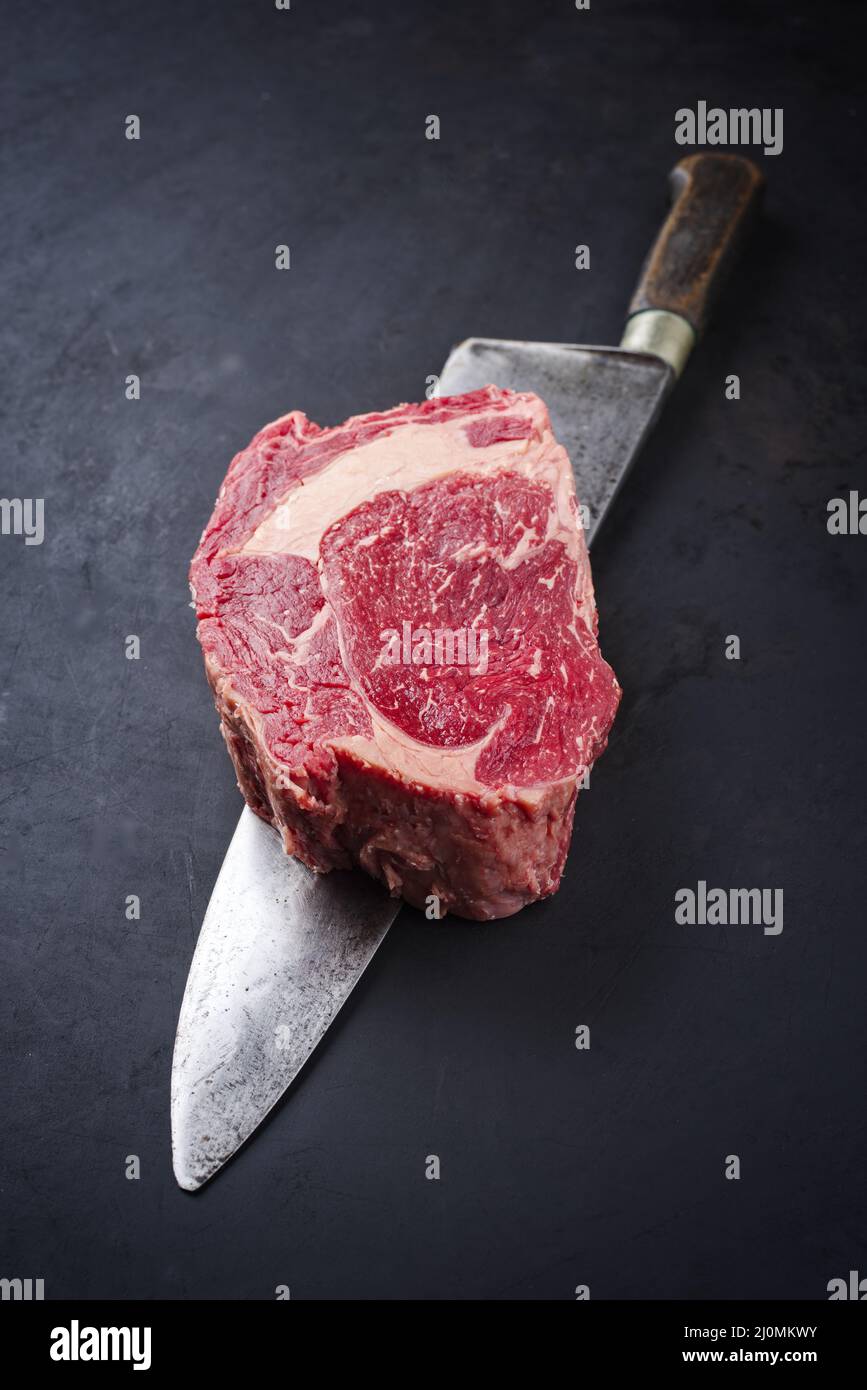 Raw dry aged wagyu rib-eye beef steaks offered as close-up on a large ...