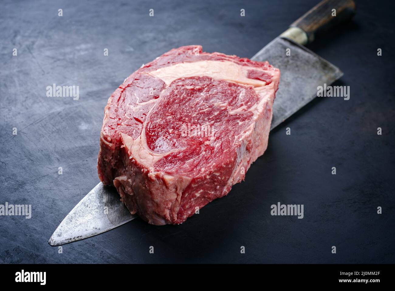 Raw dry aged wagyu rib-eye beef steaks offered as close-up on a large ...