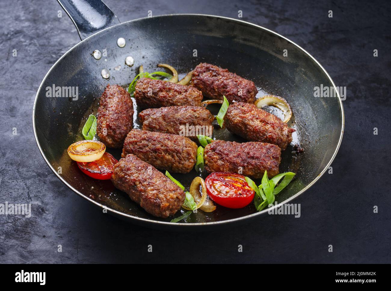 Traditional Croatian cevapi spicy meat ball rolls with tomatoes and ...