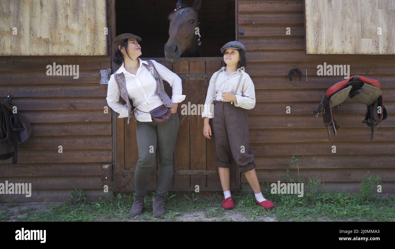 Mom and daughter in stylish vintage clothes stand on the farm near the ...