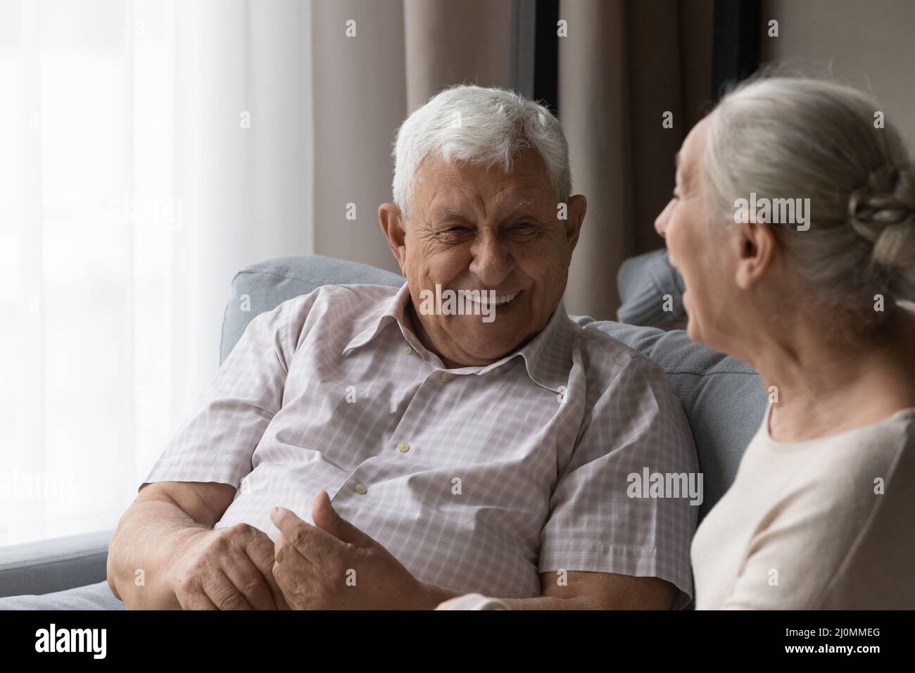 Older couple relaxing on sofa laughing talking feel happy Stock Photo ...