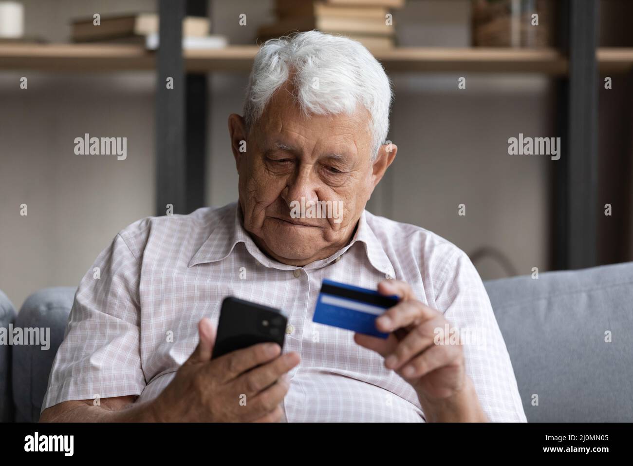 Senior man makes instant money transfer use smartphone and card Stock ...