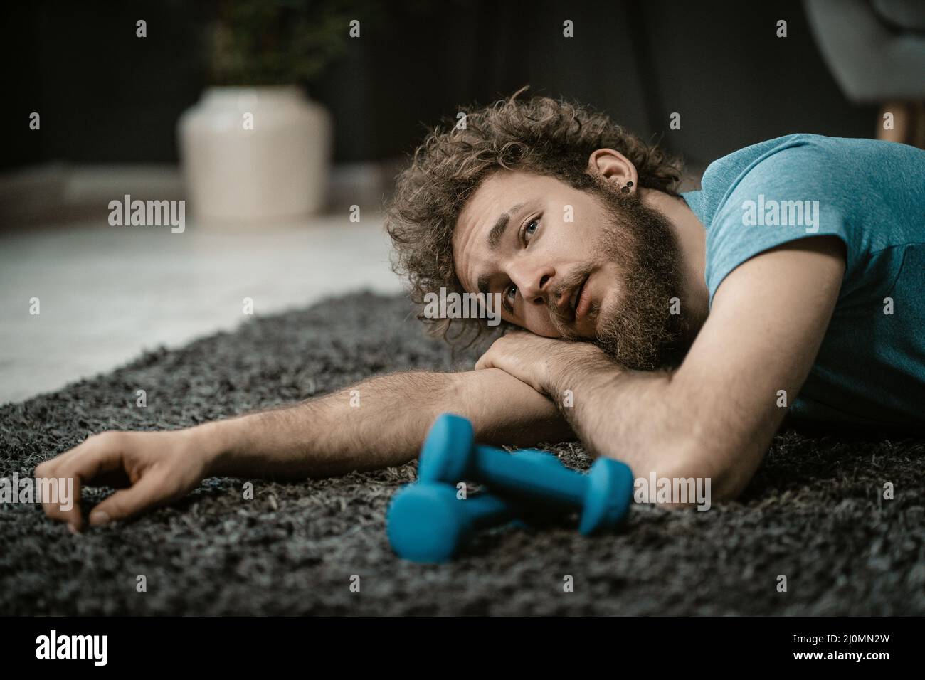 Exhausted Man After a Hard Workout Lies Tired on the Floor Next to ...