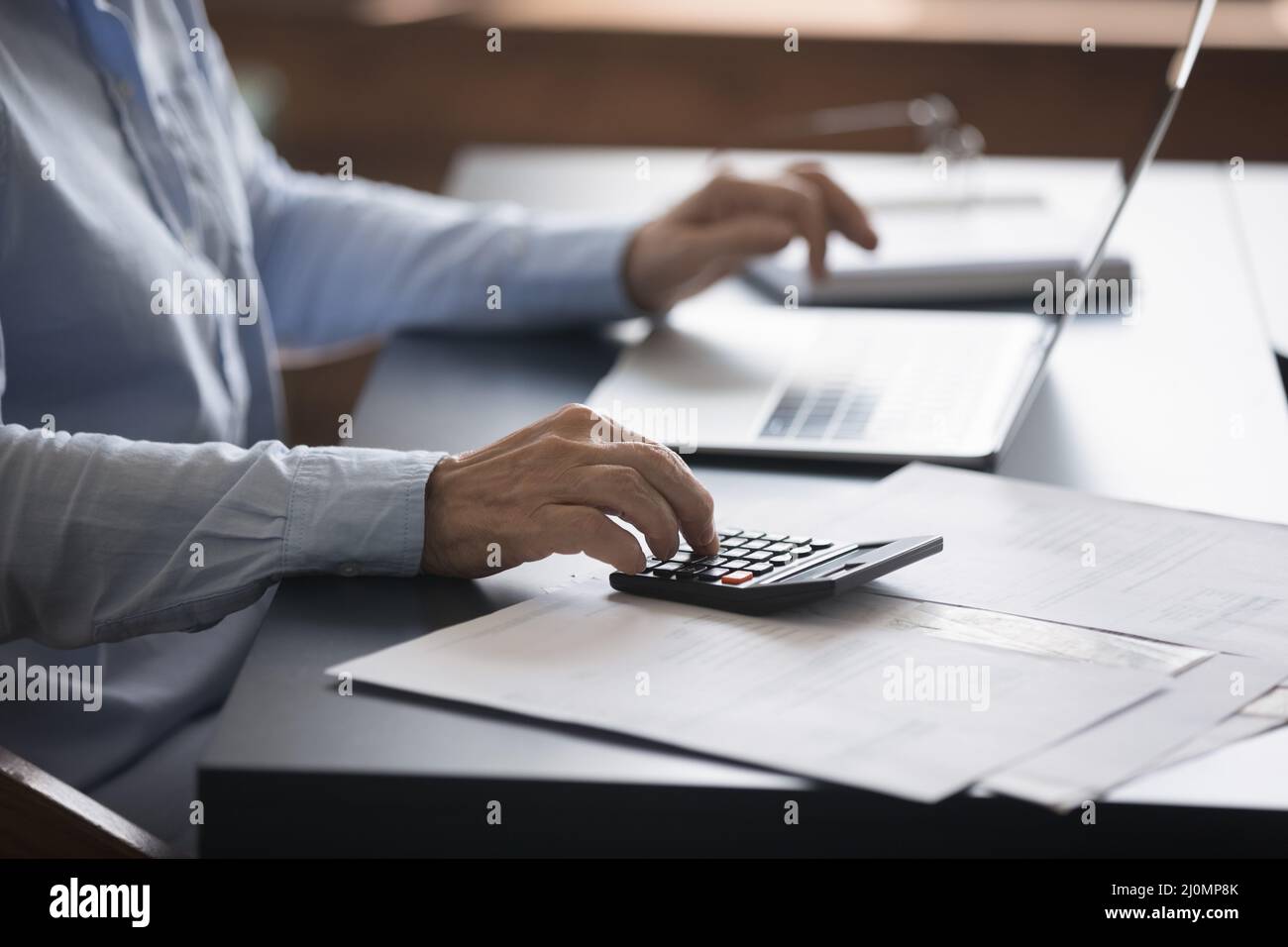 Accountant sit at desk calculates, working, pay bills via e-banking ...