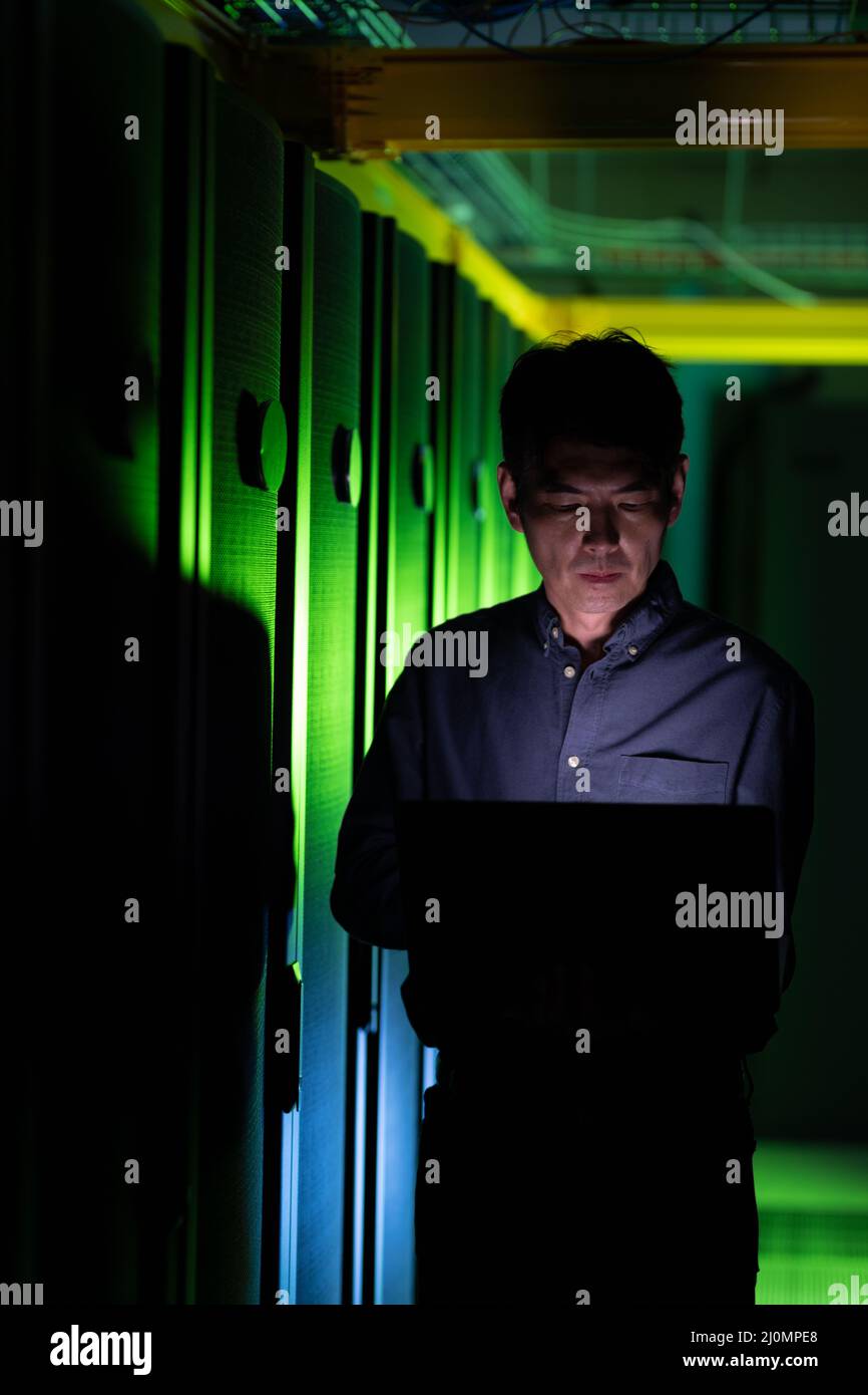 Asian male engineer using laptop in computer server room Stock Photo ...
