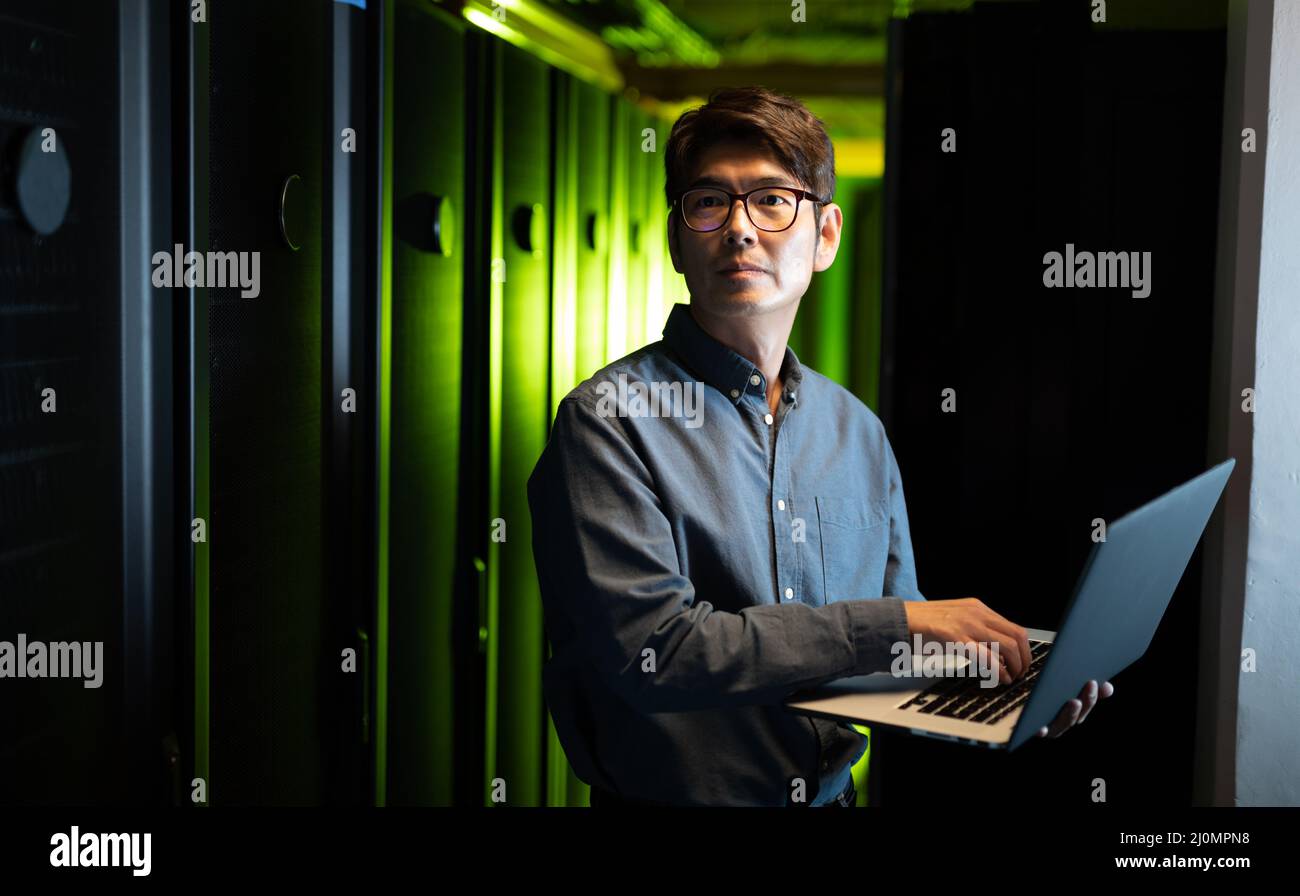 Asian male engineer using laptop in computer server room Stock Photo ...