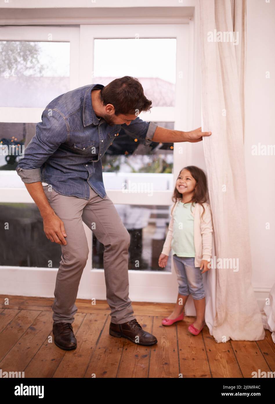 Found you. A handsome young father playing hide and seek with his young ...