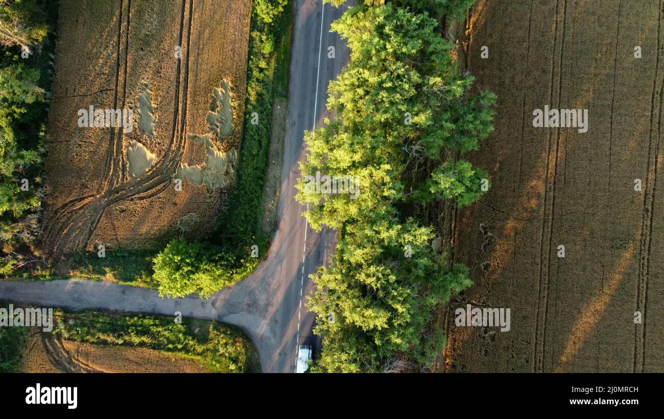 Aerial drone view flight over asphalt road with green trees Stock Photo ...