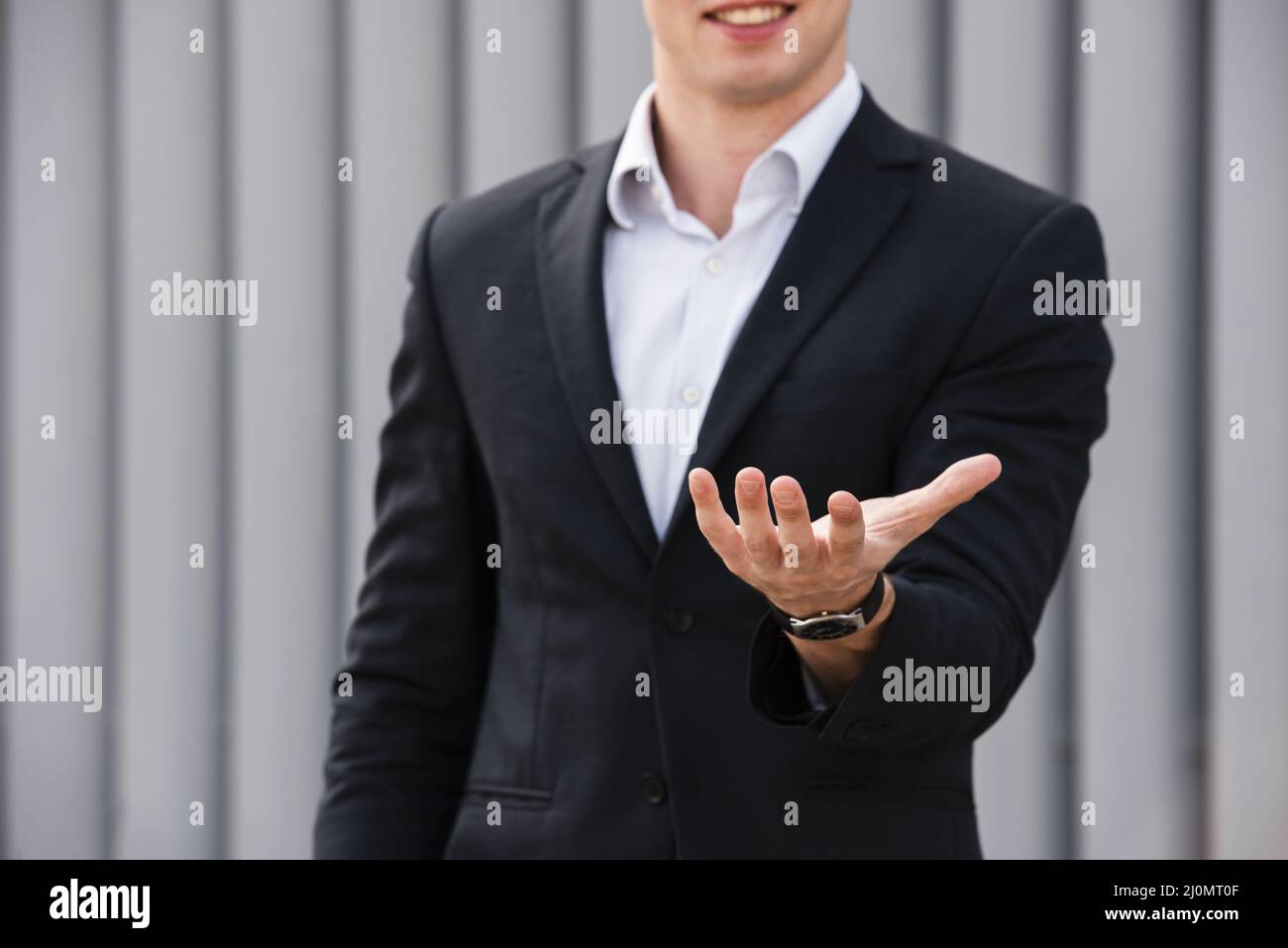 Front view businessman holding hand out Stock Photo - Alamy