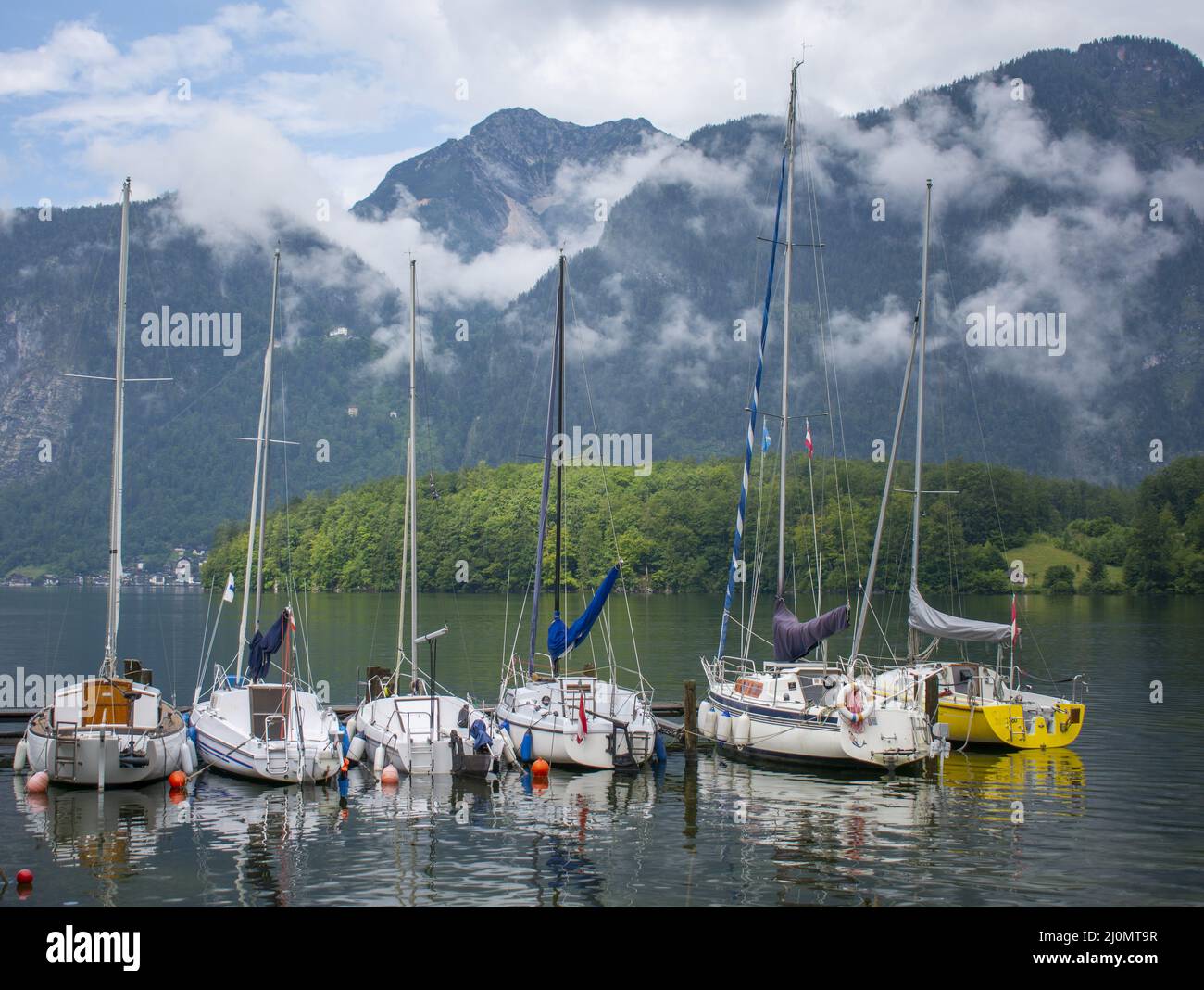 Line of small boats docked at the lake. Row of the small ships. The ...