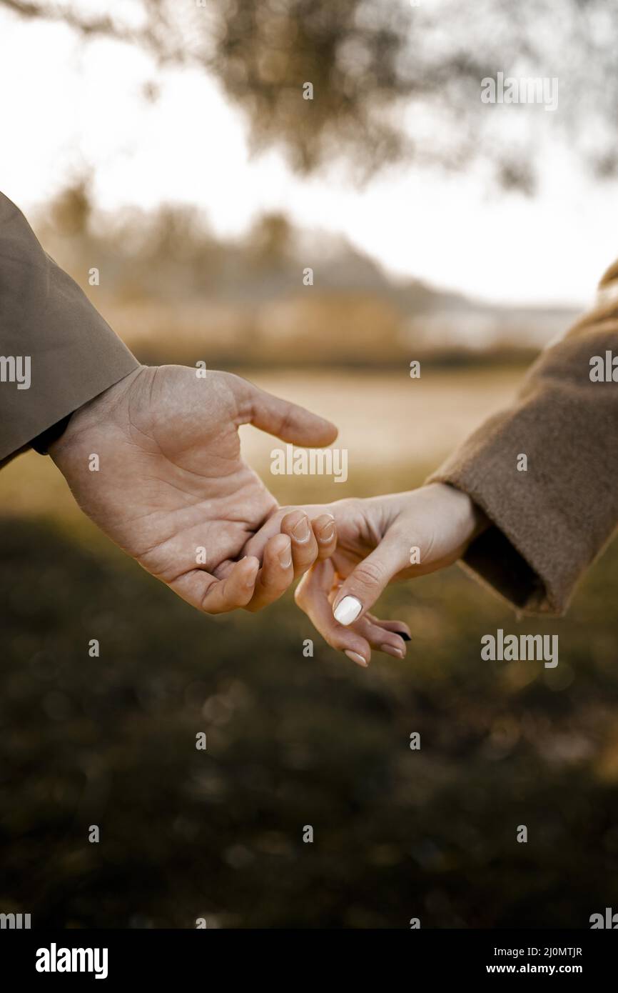 Close up couple holding hands outside Stock Photo - Alamy