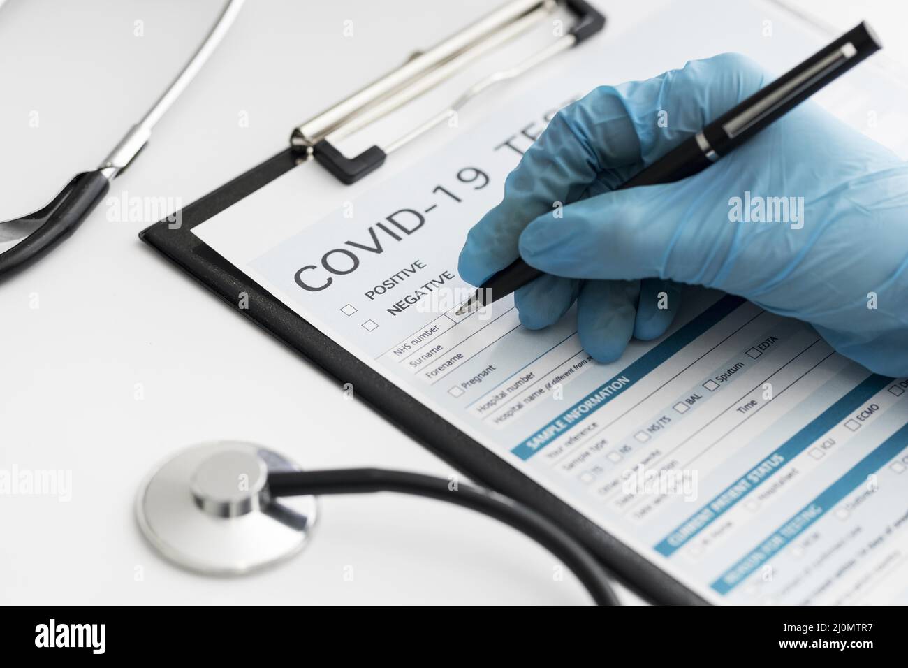 Close up doctor completing covid medical form Stock Photo - Alamy