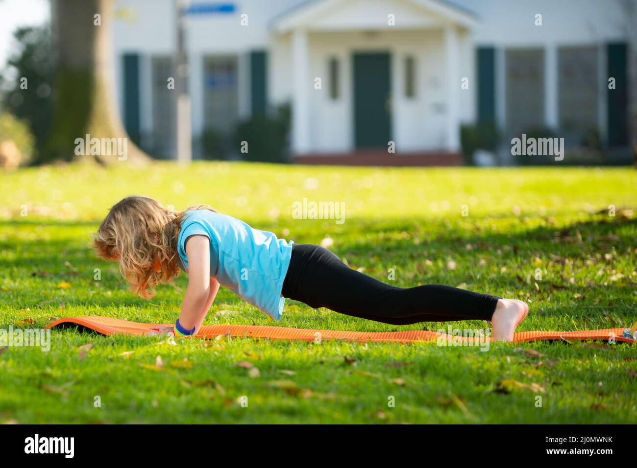 Kid doing pushing up on roll mat in park. Kids practicing push up ...