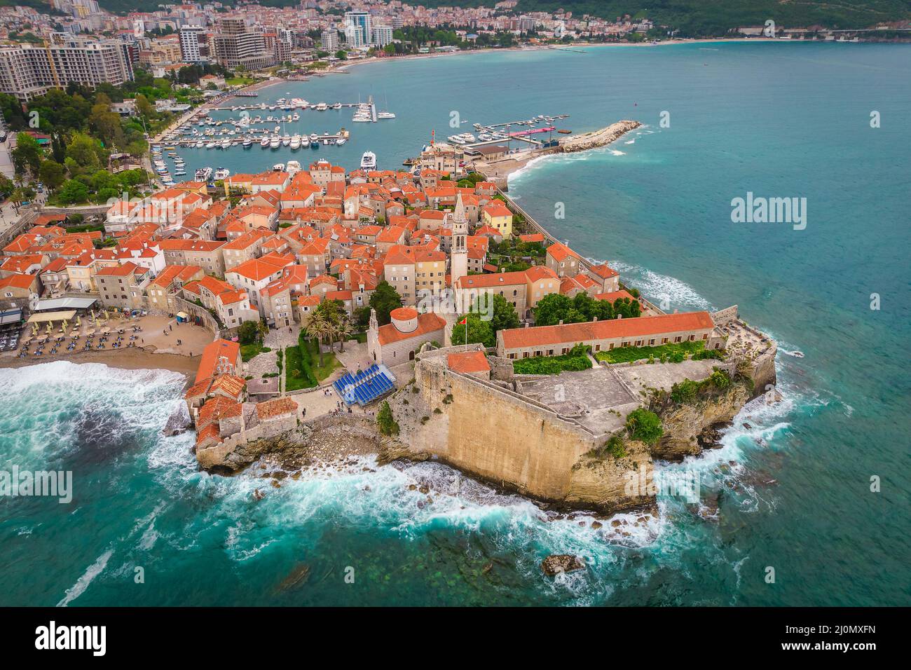Aerial view of Budva old town with mighty sea waves, famous touristic ...