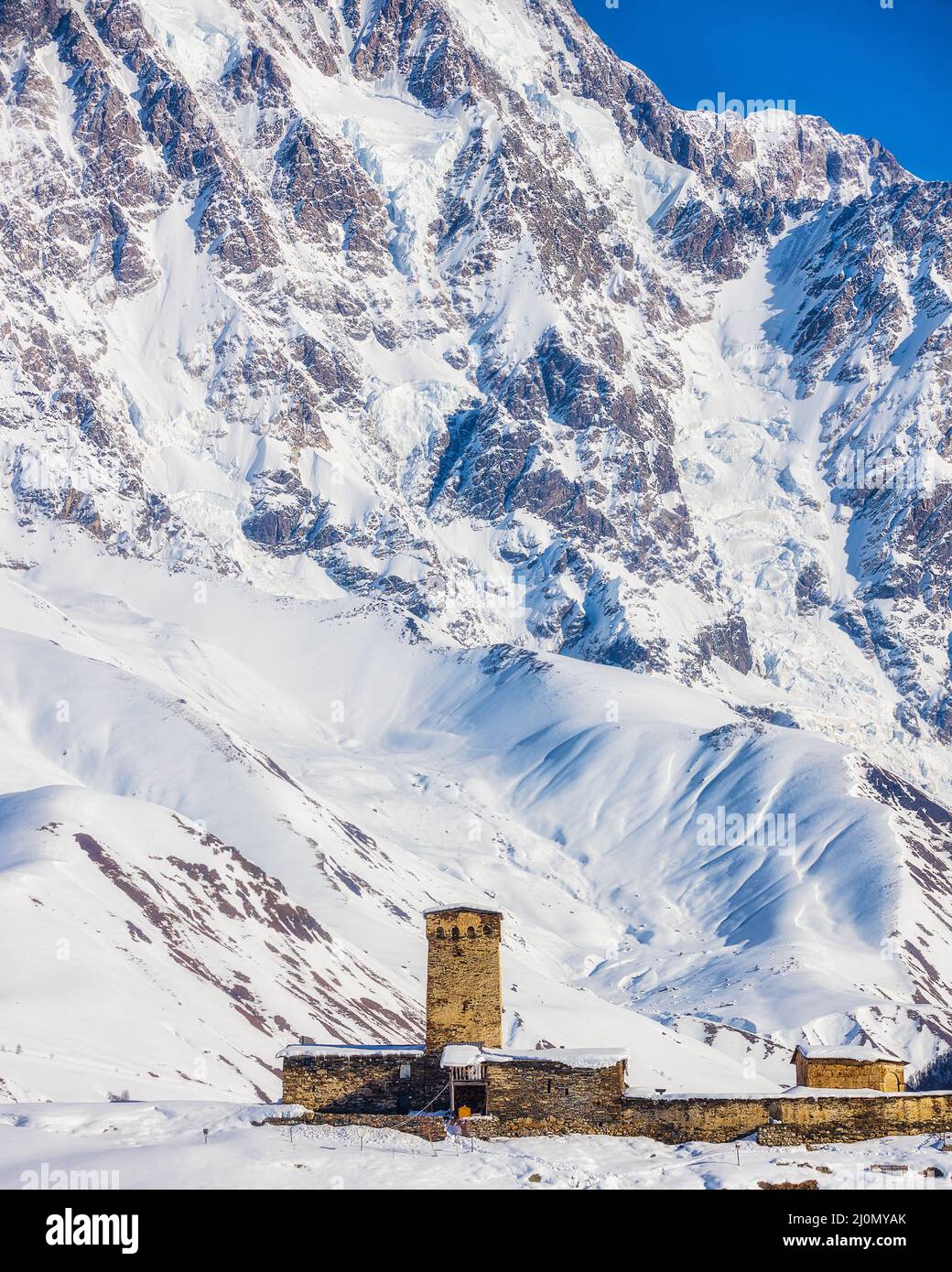 Old Lamaria church and rocky slopes of Shkhara mountain in Ushguli ...